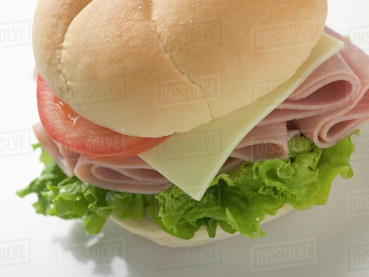 Bread roll filled with ham, cheese, lettuce and tomato - Stock Photo ...