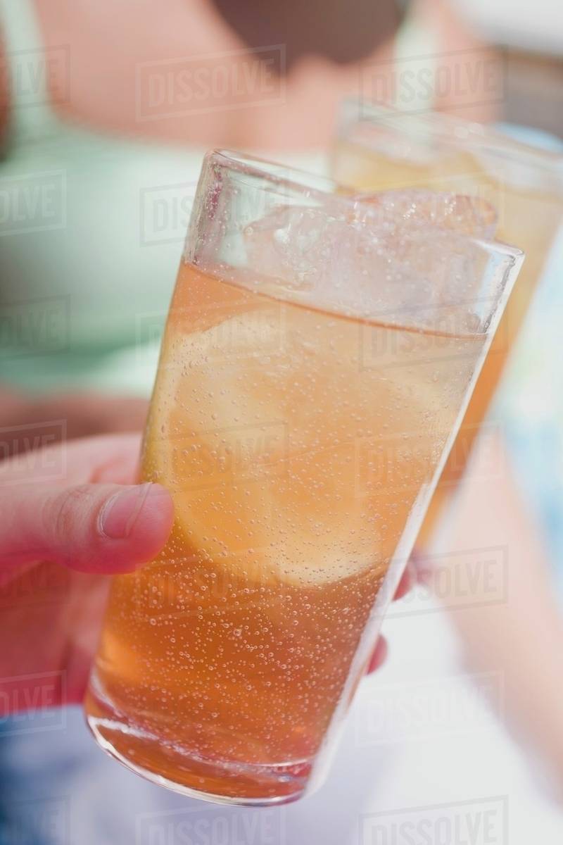Hands holding two glasses of iced tea - Stock Photo - Dissolve