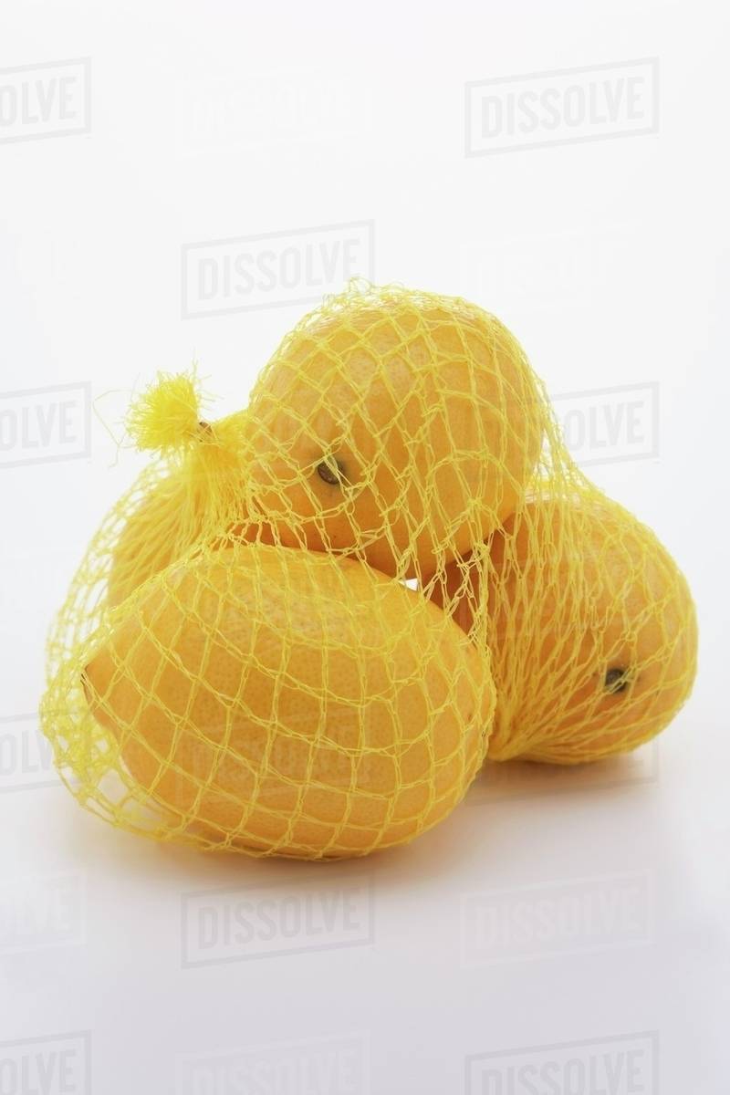 Four lemons in a net - Royalty-free Stock Photo | Dissolve