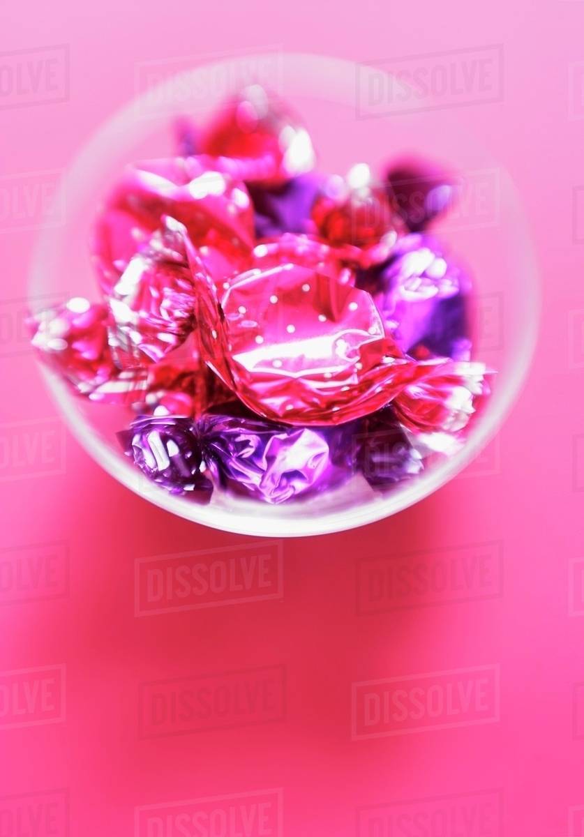 Sweets in pink and purple wrappers in a small bowl - Royalty-free Stock ...