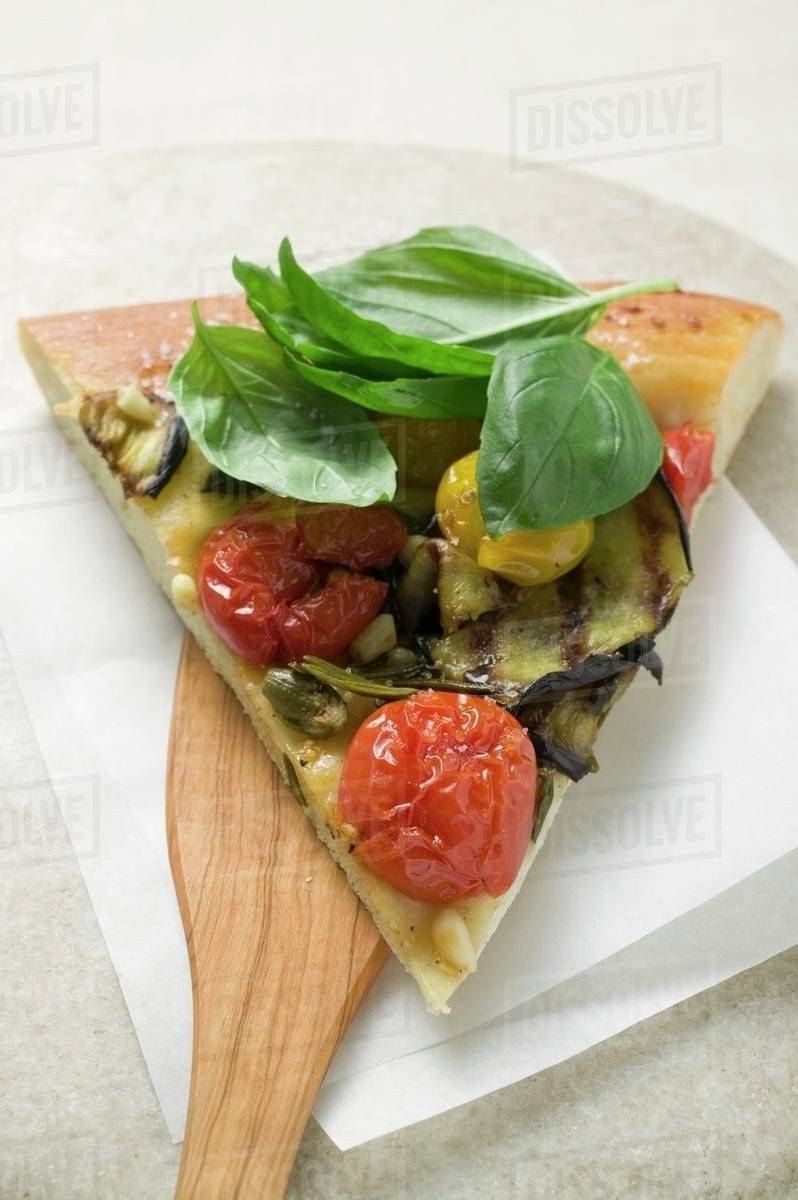 Slice of pizza with aubergines, cherry tomatoes & basil - Stock Photo ...