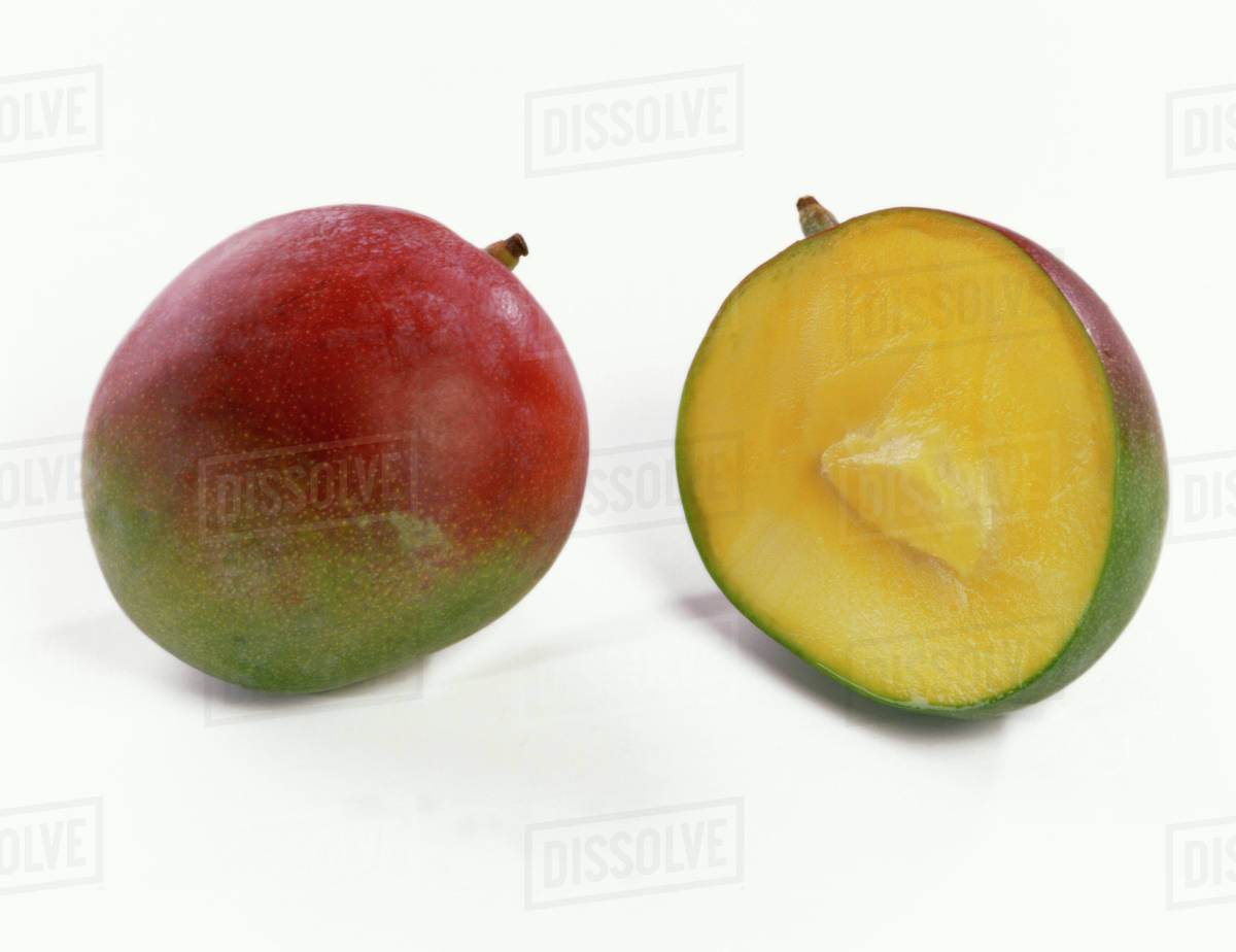 A mango beside a mango half - Royalty-free Stock Photo | Dissolve