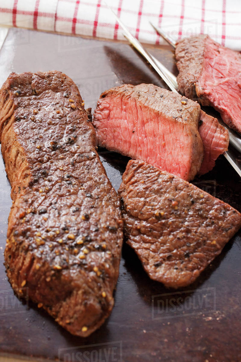 Two beef steaks, one sliced - Royalty-free Stock Photo | Dissolve