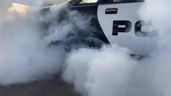 Close up view. Burning rubber and smoking tire. Wheel rotates in one ...