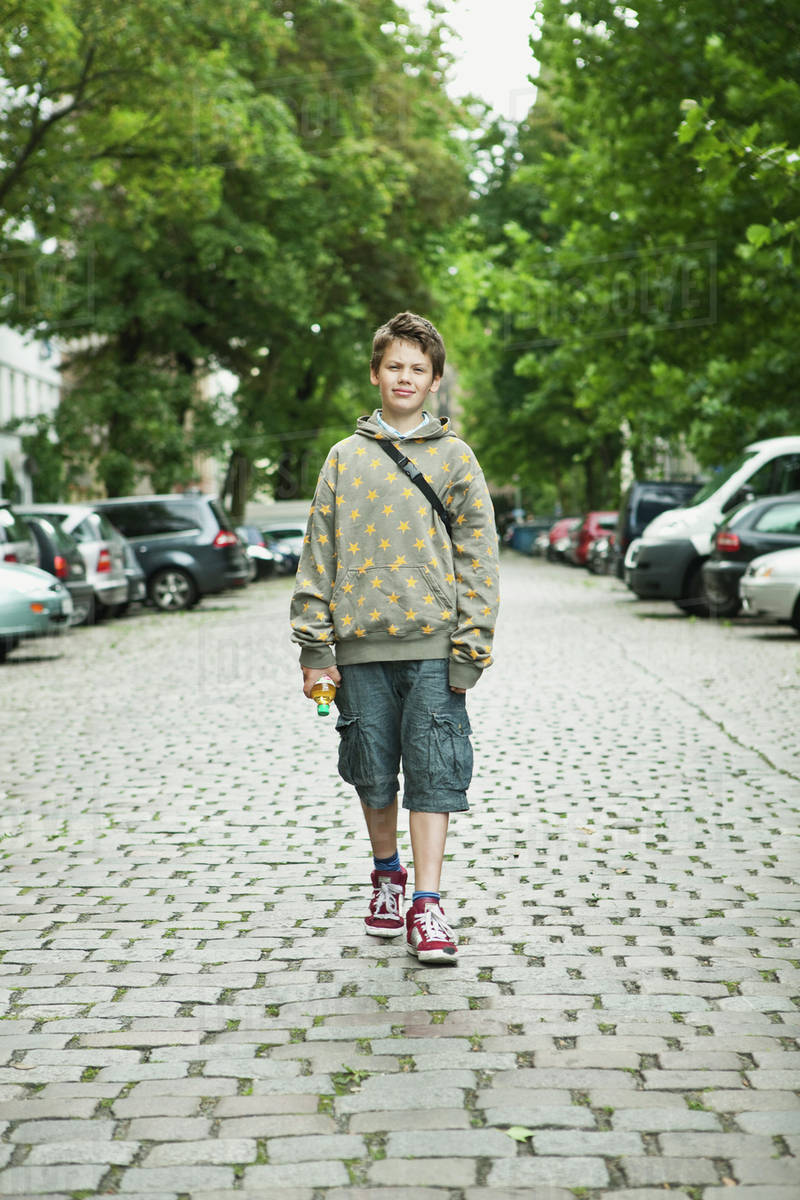 Germany, Berlin, Boy standing in street - Stock Photo - Dissolve