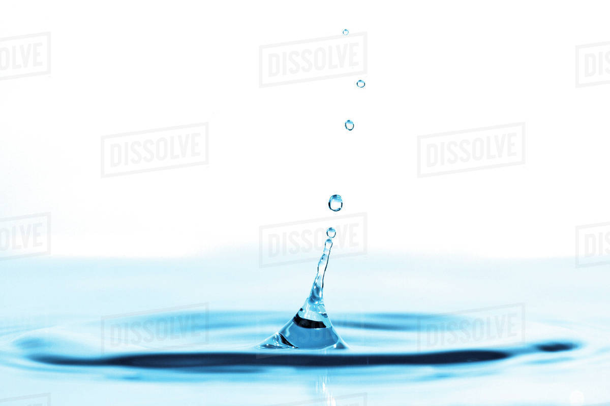Water drop falling into water, close-up - Stock Photo - Dissolve