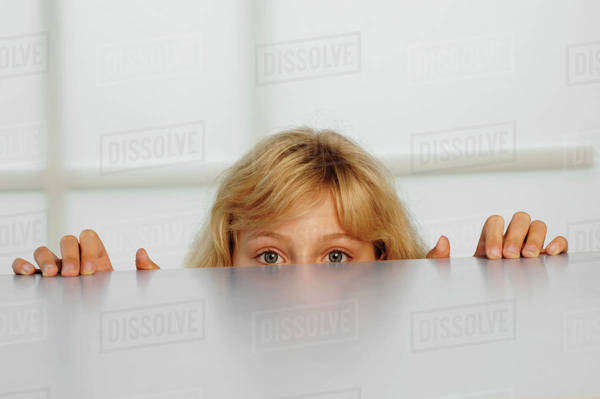 Blond girl hiding - Stock Photo - Dissolve
