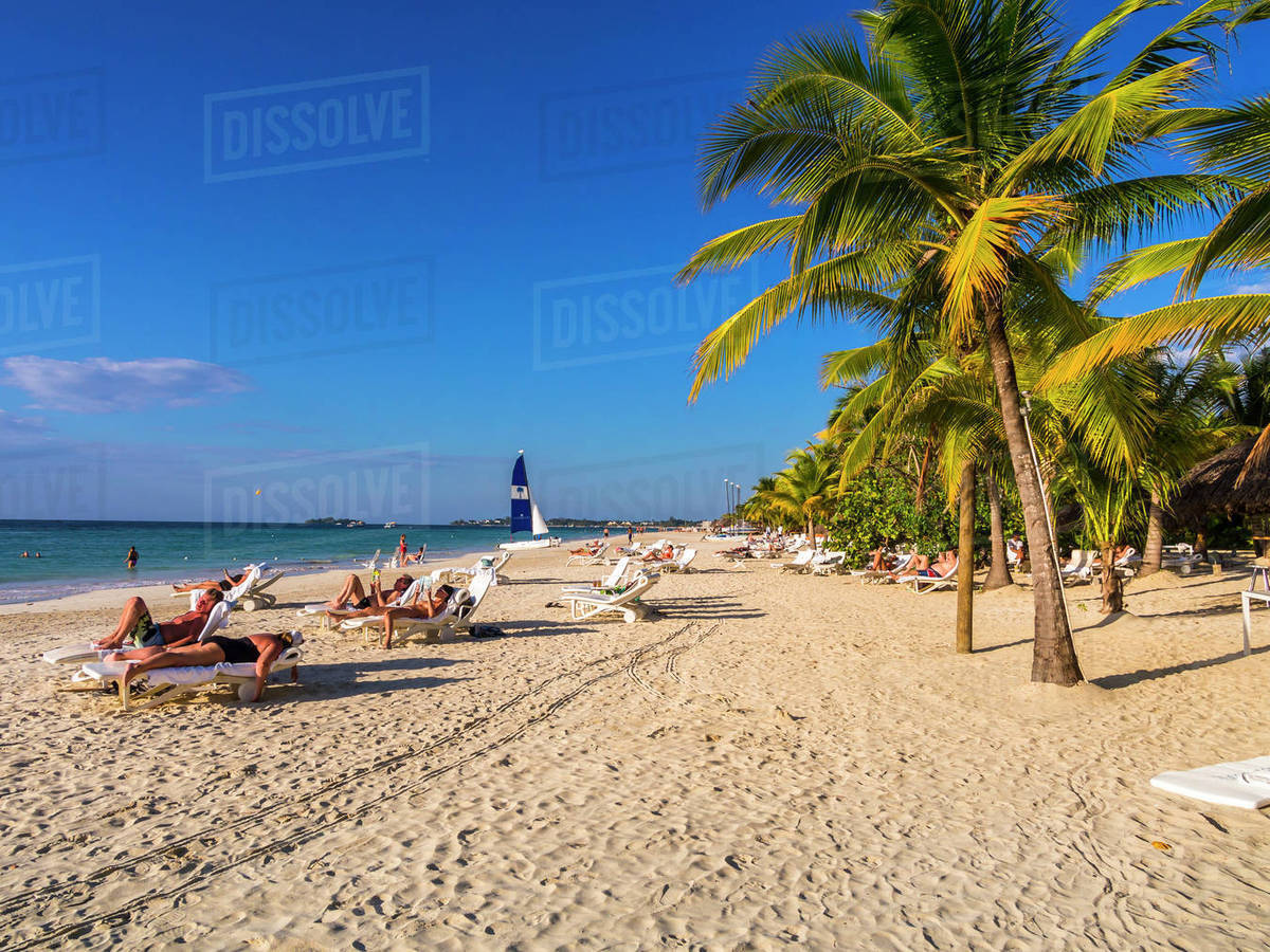 Jamaica Negril Tourists Sunbathing On The Beach Stock Photo Dissolve