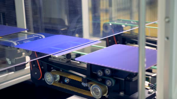 Solar module cells are moving along the conveyor belt one by one ...