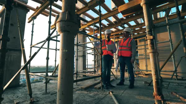 Two engineers are having a discussion construction plan among the ...