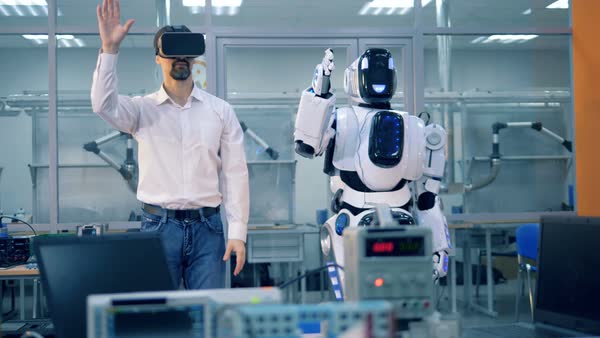 A robot and an adult man are moving their body parts together - Stock ...