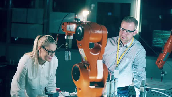 Engineers are watching a robotic arm at modern science lab - Stock ...