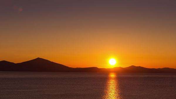 Scenic sunrise background sun rising behind hills wide view timelapse ...