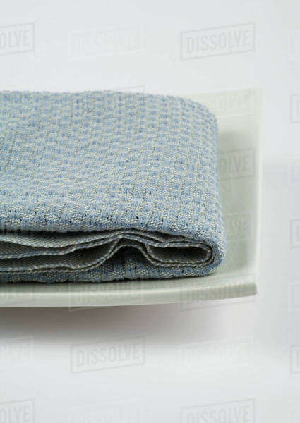 Towel folded on square dish - Stock Photo - Dissolve