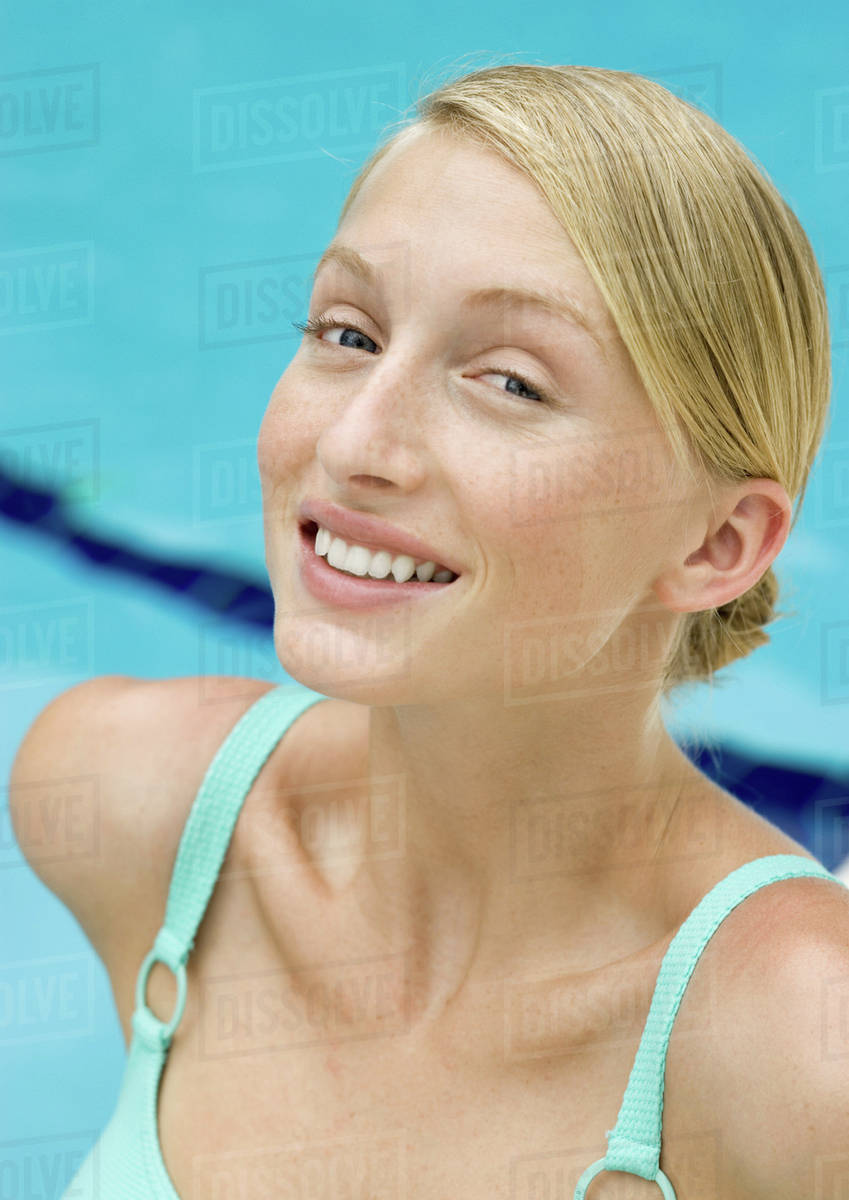 Young woman smiling, portrait, pool in background - Stock Photo - Dissolve