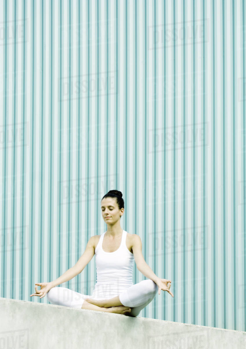 Woman sitting in lotus position - Stock Photo - Dissolve