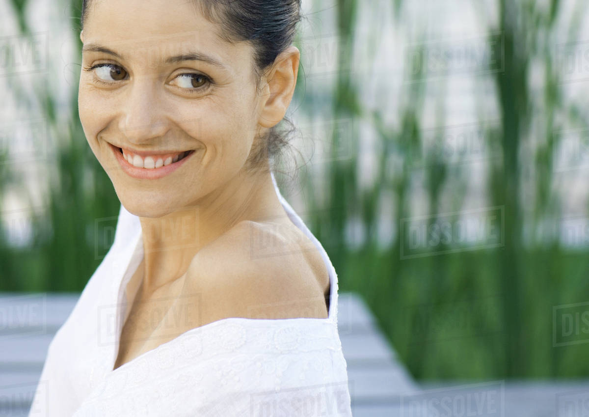 Woman smiling, looking over shoulder - Royalty-free Stock Photo | Dissolve