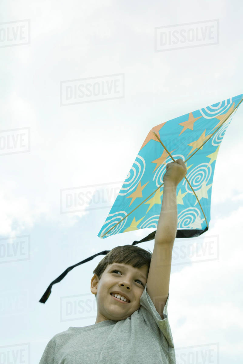 Boy holding kite above head, low angle view - Royalty-free Stock Photo ...