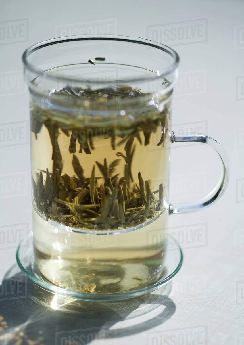 Tea steeping in mug with tea strainer - Stock Photo - Dissolve