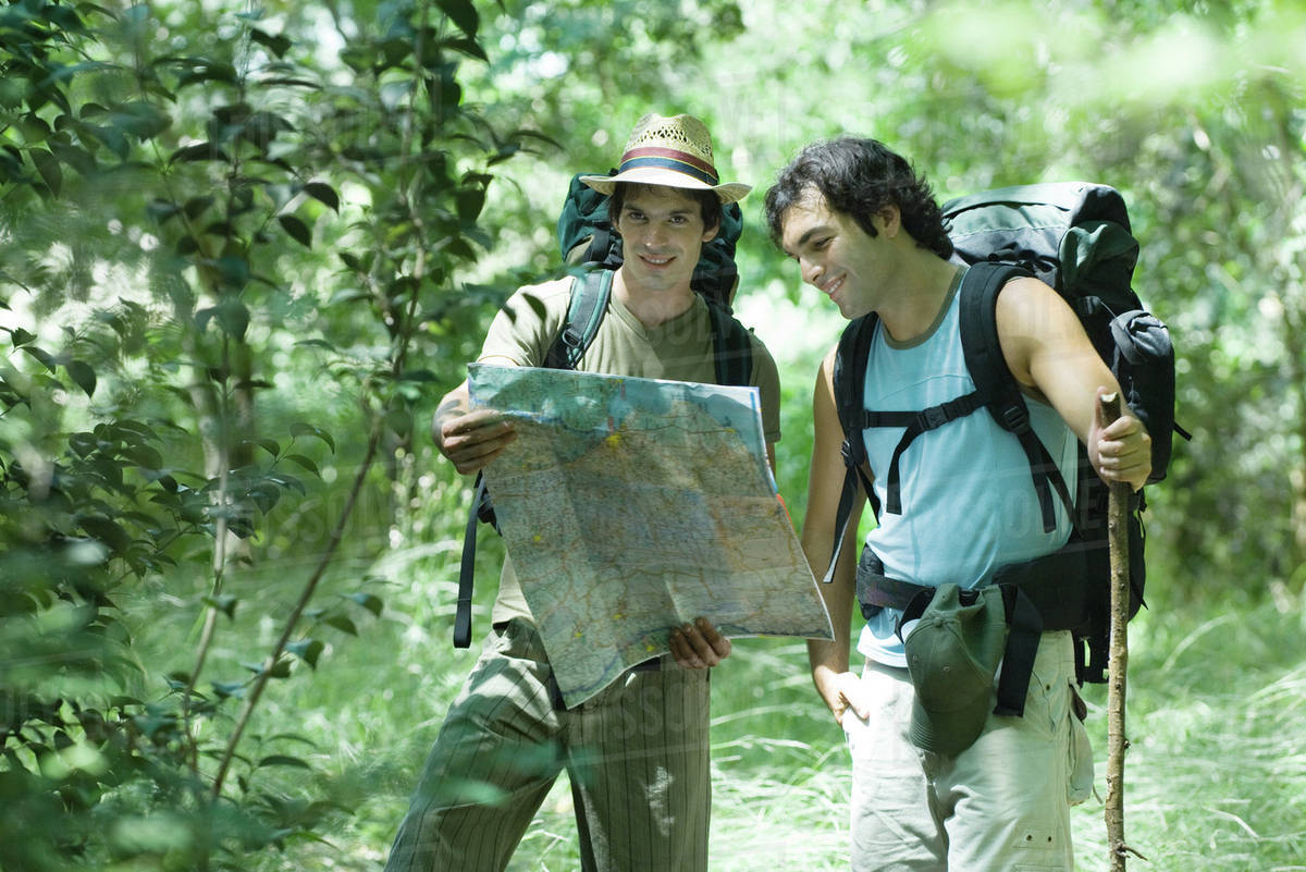 Hikers standing, looking at map - Stock Photo - Dissolve