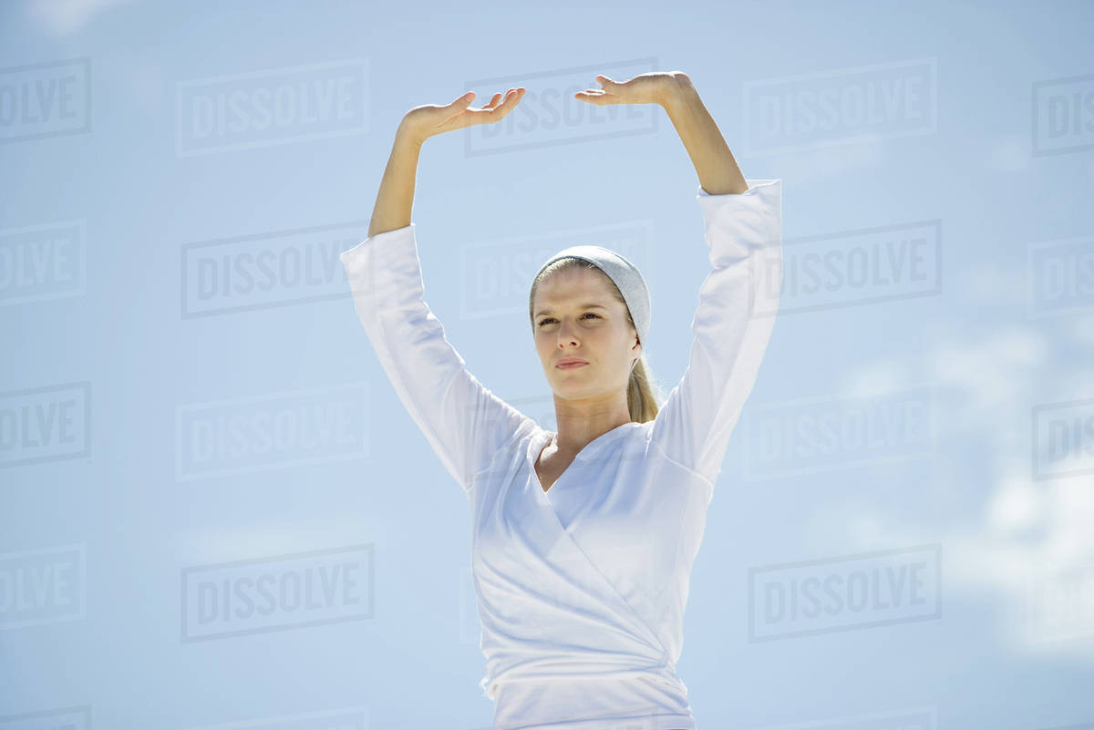 Young woman with arms over head, low angle view - Royalty-free Stock ...