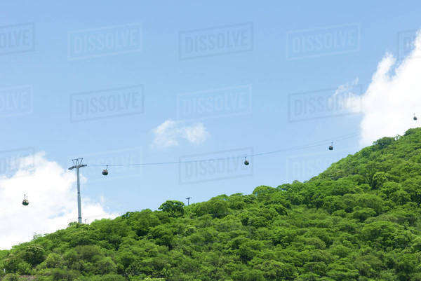 Cable cars going up side of lush mountain - Royalty-free Stock Photo ...