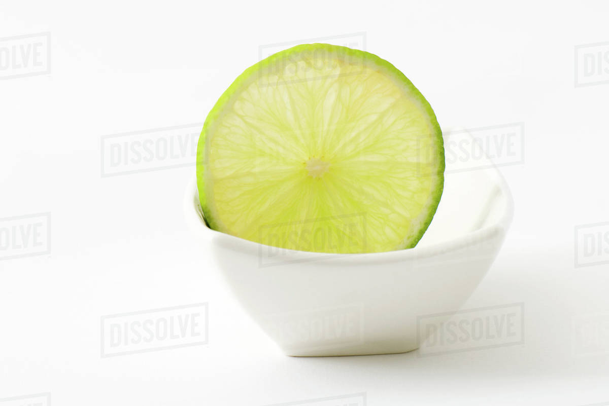 Slice of lime in small dish - Royalty-free Stock Photo | Dissolve