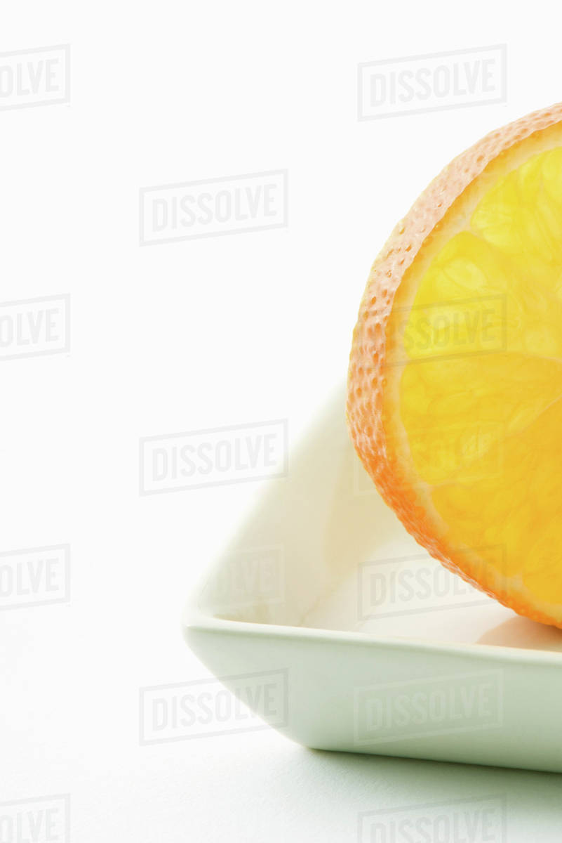 Orange slice in small dish, close-up - Royalty-free Stock Photo | Dissolve