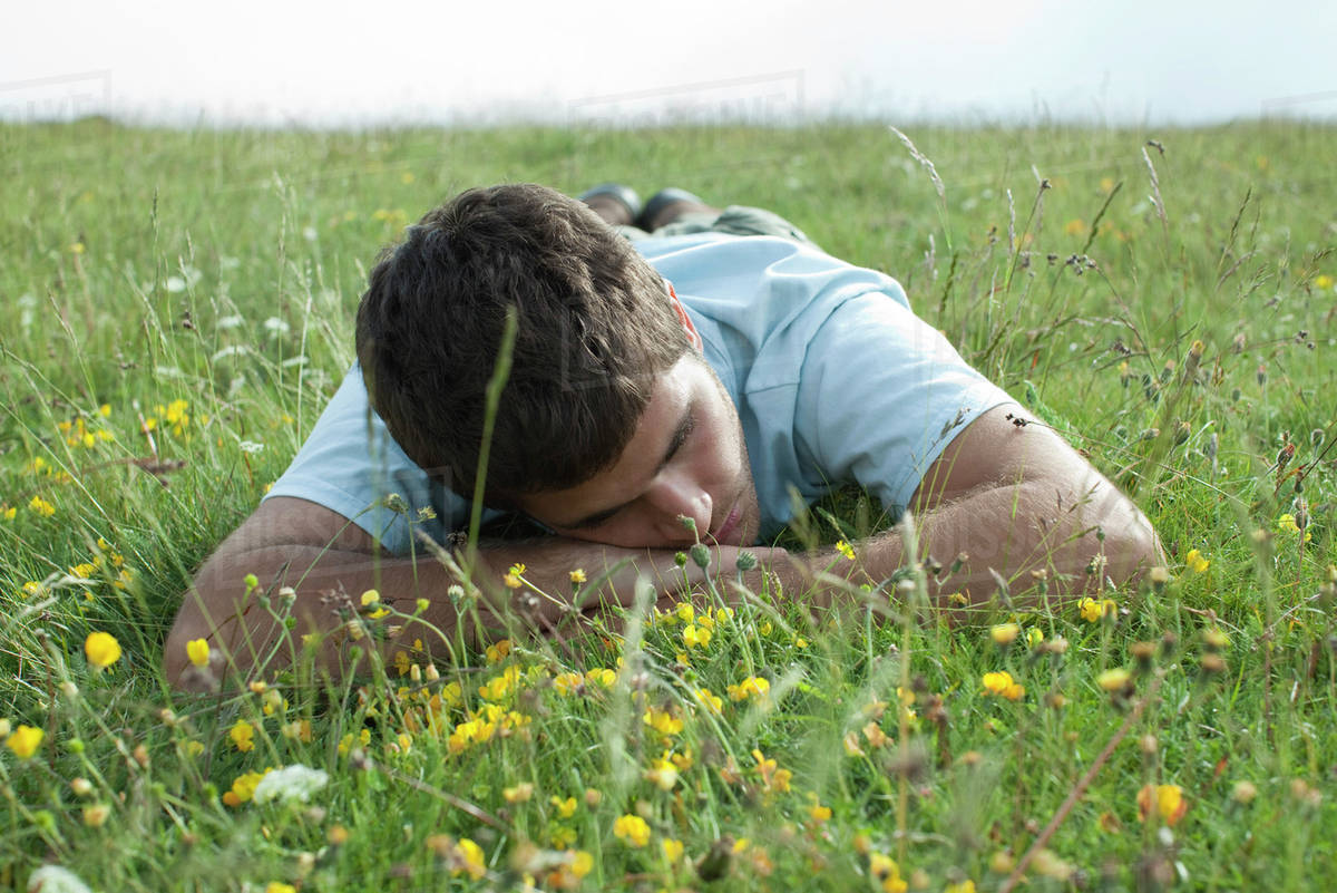 Man napping on meadow - Royalty-free Stock Photo | Dissolve