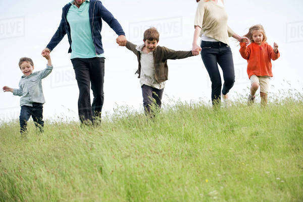 Family running together in field - Royalty-free Stock Photo | Dissolve