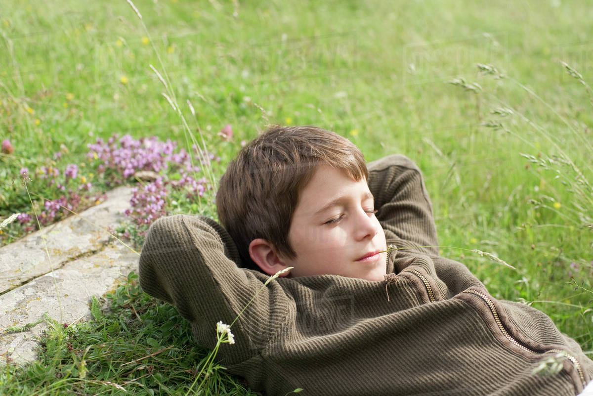 Boy napping on grass - Royalty-free Stock Photo | Dissolve