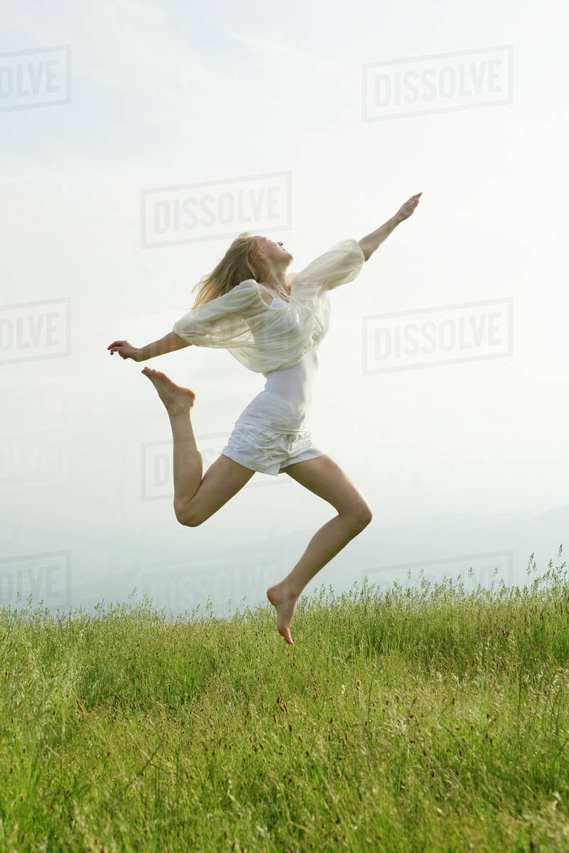 Young woman jumping in midair, side view - Royalty-free Stock Photo ...