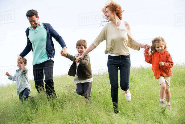Family running together in field - Royalty-free Stock Photo | Dissolve