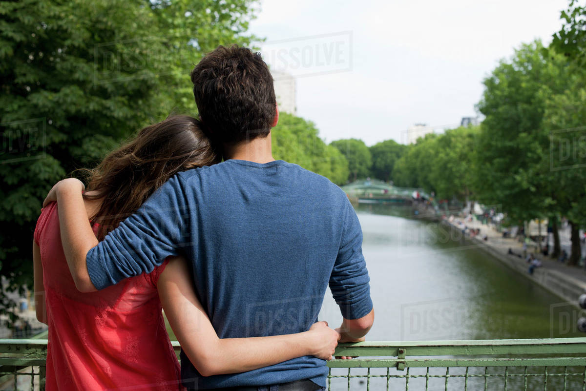 Couple standing together on bridge, rear view - Royalty-free Stock ...
