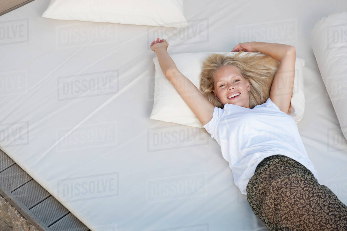 Young woman relaxing on bed - Royalty-free Stock Photo | Dissolve
