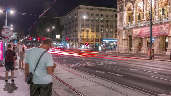 Old tram comes on a stop with the Vienna Opera House Behind timelapse ...