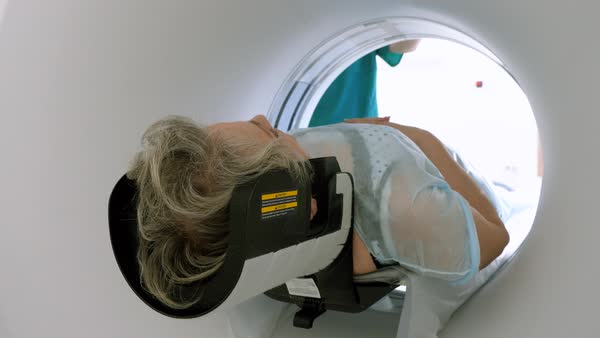Close-up shot of a female mature patient lying on a table of CT scan ...