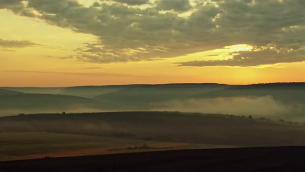 Misty autumn morning landscape at sunset with fogs, cloudy sky and ...