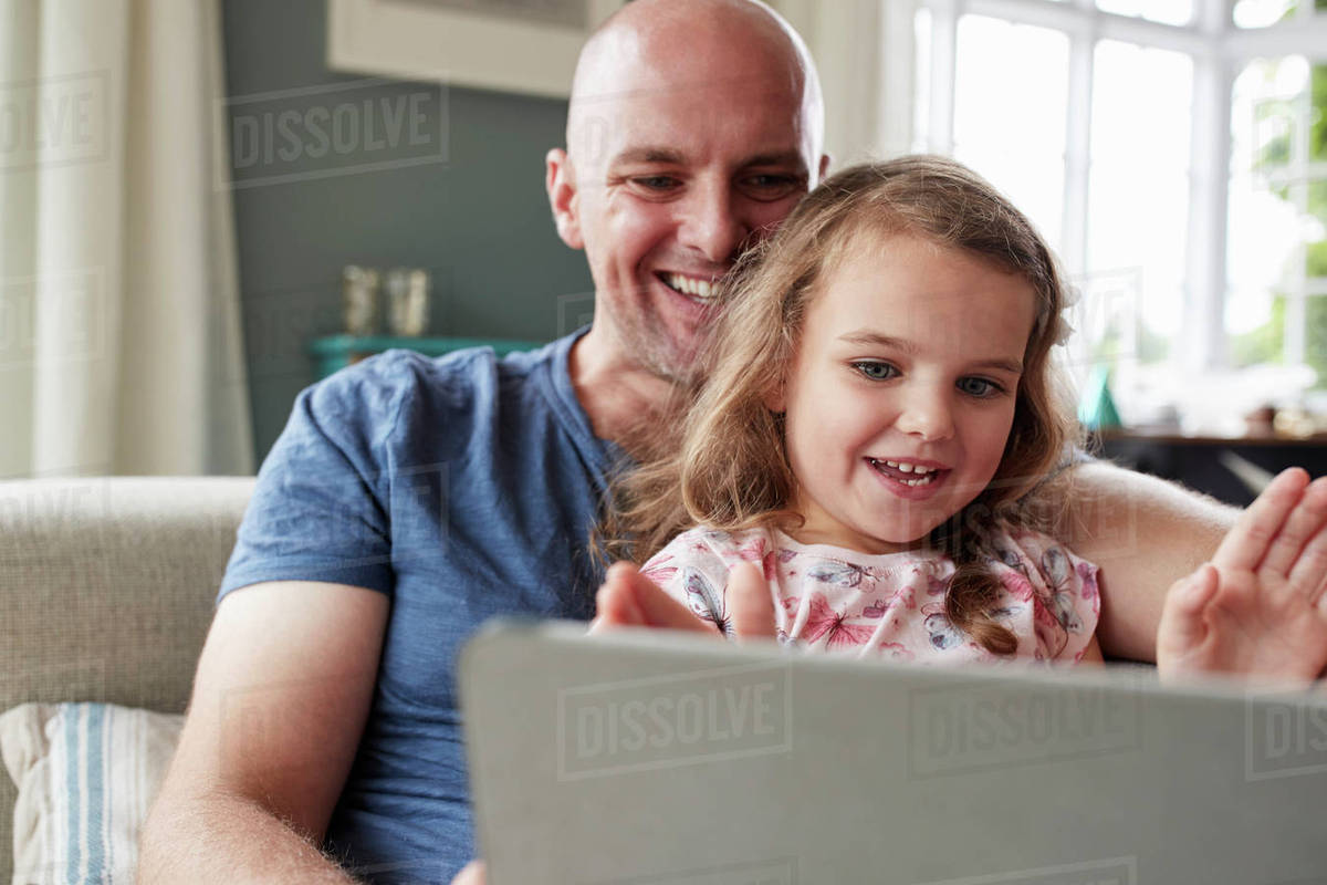 Father and daughter using tablet computer at home, close up - Royalty ...