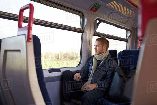 Young man sitting in train carriage on railway journey - Stock Photo ...