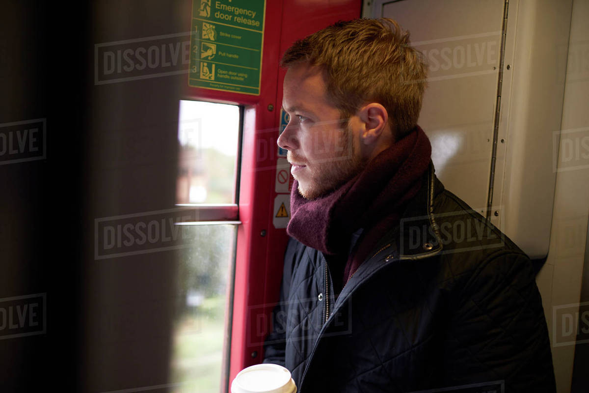 Young man standing in train carriage on railway journey - Stock Photo ...
