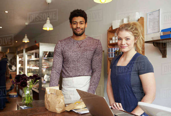 Portrait of delicatessen staff standing at checkout - Stock Photo ...