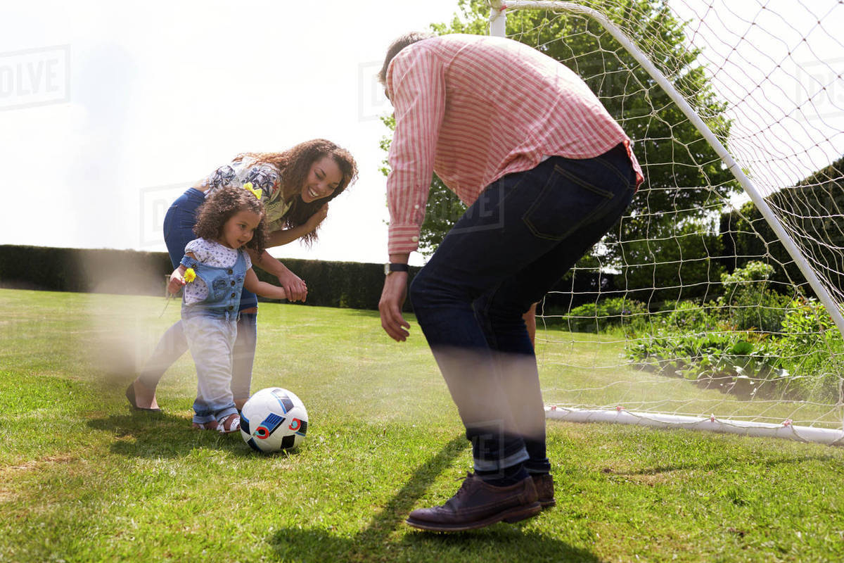 Parents playing football with their young daughter - Royalty-free Stock ...