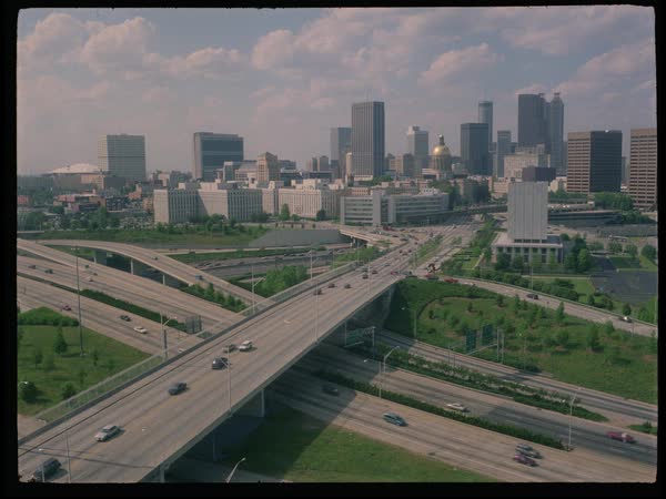 Traffic on freeway interchange with city skyline in the background ...
