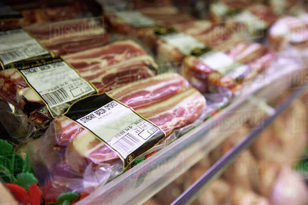 Arranged packets of bacon in chilled display - Royalty-free Stock Photo ...