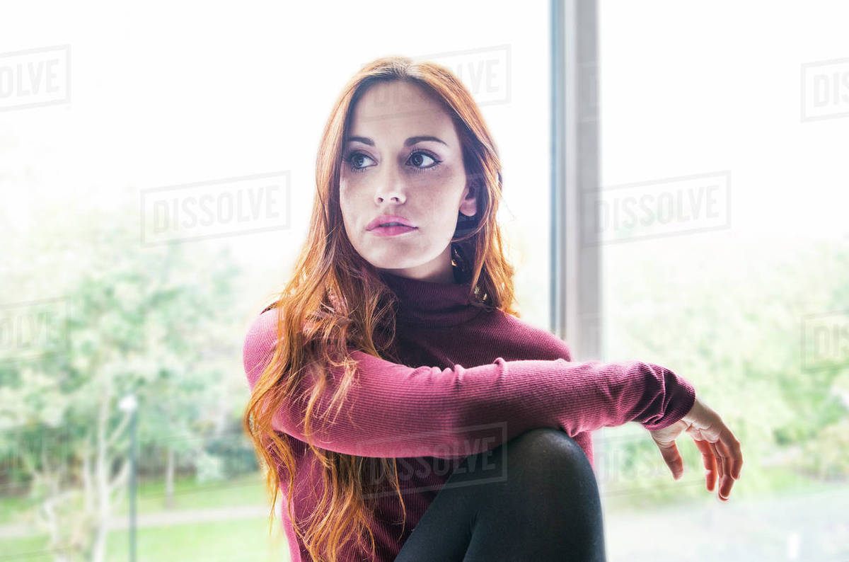 Portrait of an attractive young woman sitting by a window - Stock Photo ...