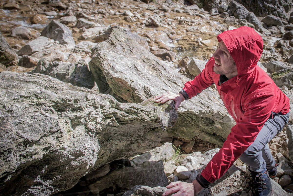 A mountaineer climbing over rocks in rugged terrain - Stock Photo ...