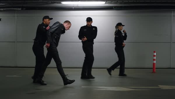 Police team arresting criminal. Police officers on duty walking with ...