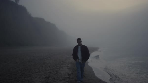 Sad man walking sea shore. Upset guy feeling lonely. Model looking ...