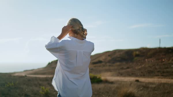 Blonde girl walking castle back view. Calm woman stepping summer ...